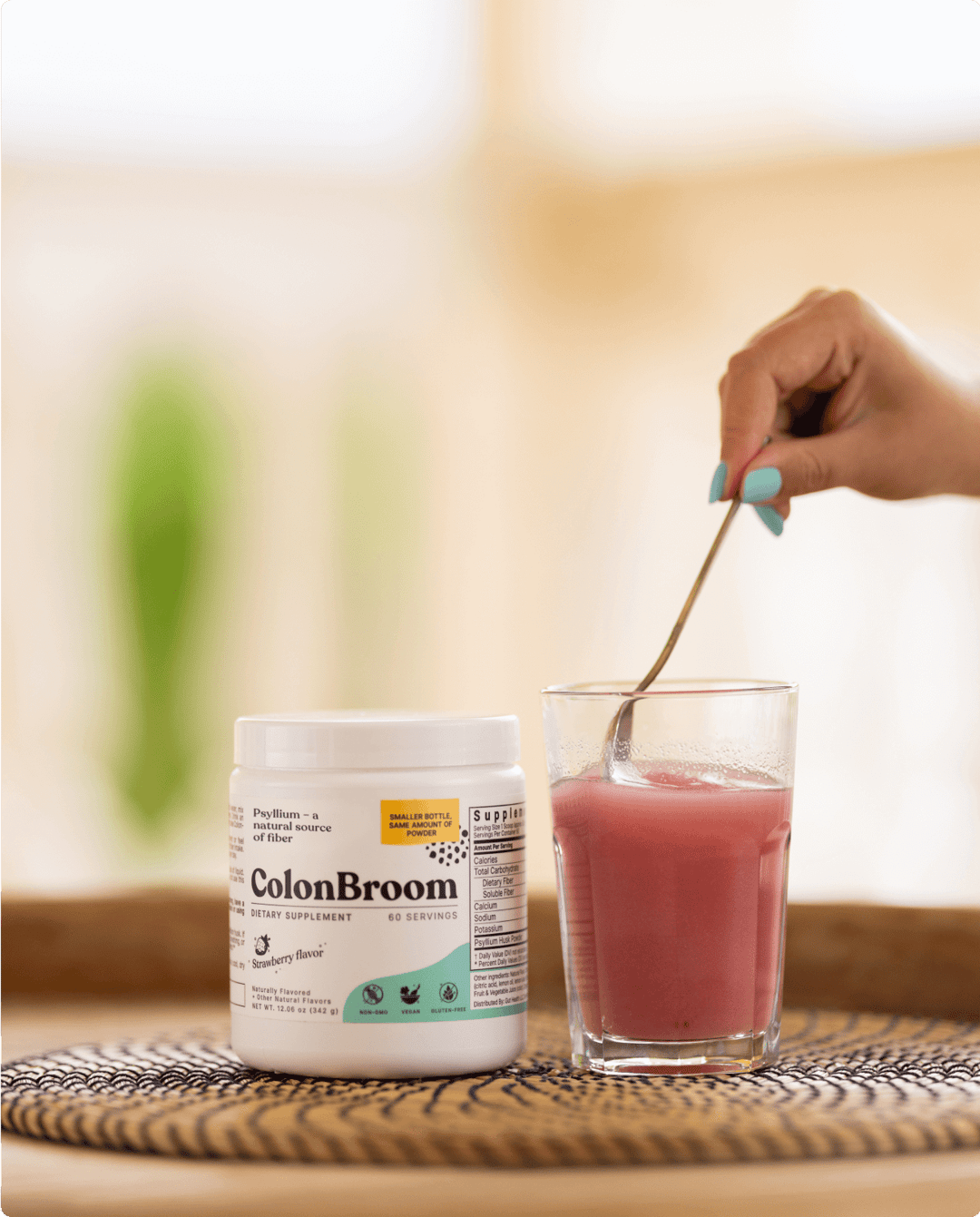 Woman stirring Colonbroom in a glass